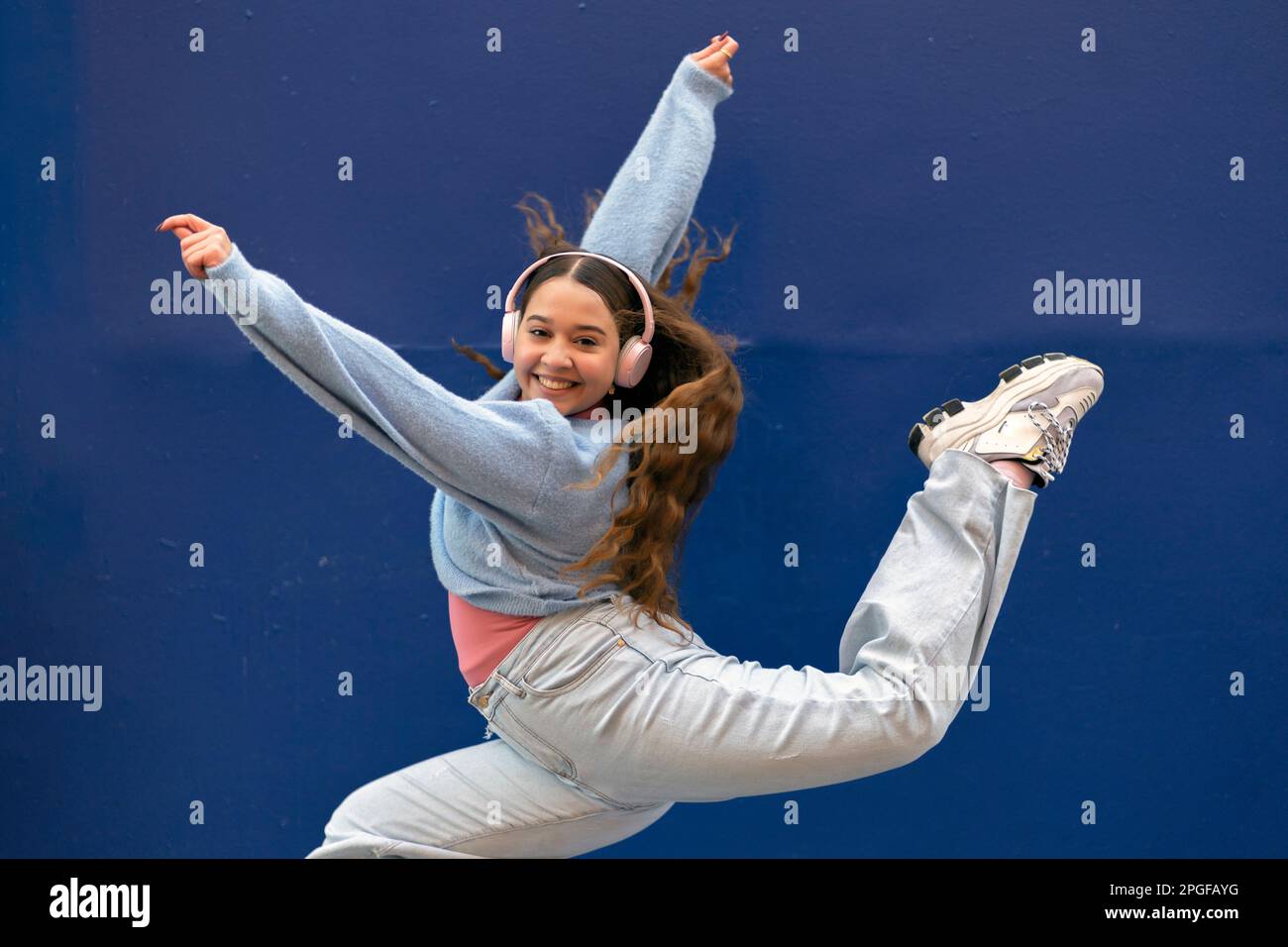 young girl jumping while listening to music Stock Photo - Alamy