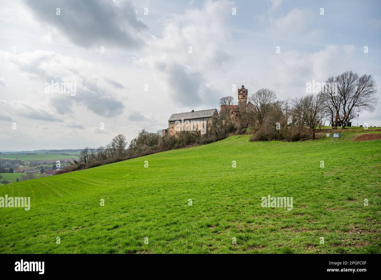 Beautiful Ronneburg Castle on top of a hill with meadow in front and ...