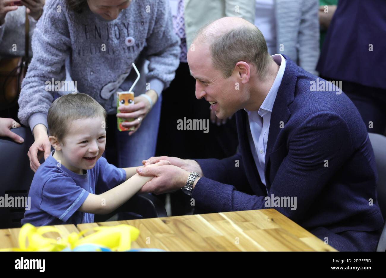 The Prince of Wales holds hands with Tymofii, aged 4, as he speaks with ...