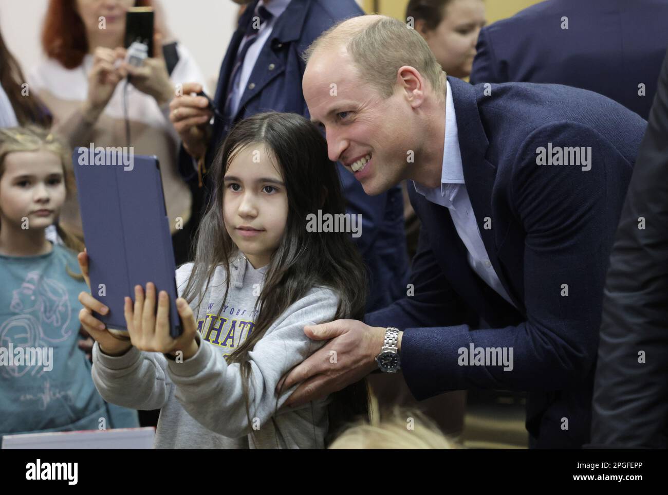 The Prince of Wales poses for photos with a young Ukrainian resident ...