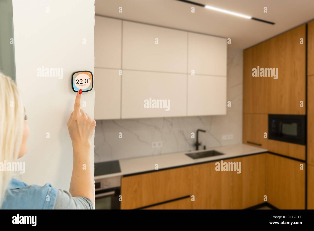 Smiling Indian woman using modern smart home system, controller on wall ... Smiling Indian woman using modern smart home system, controller on wall ...