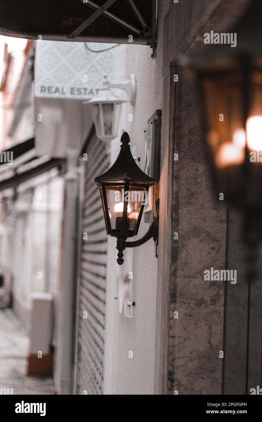 Street light on the side of a building next to a sidewalk Stock Photo ...