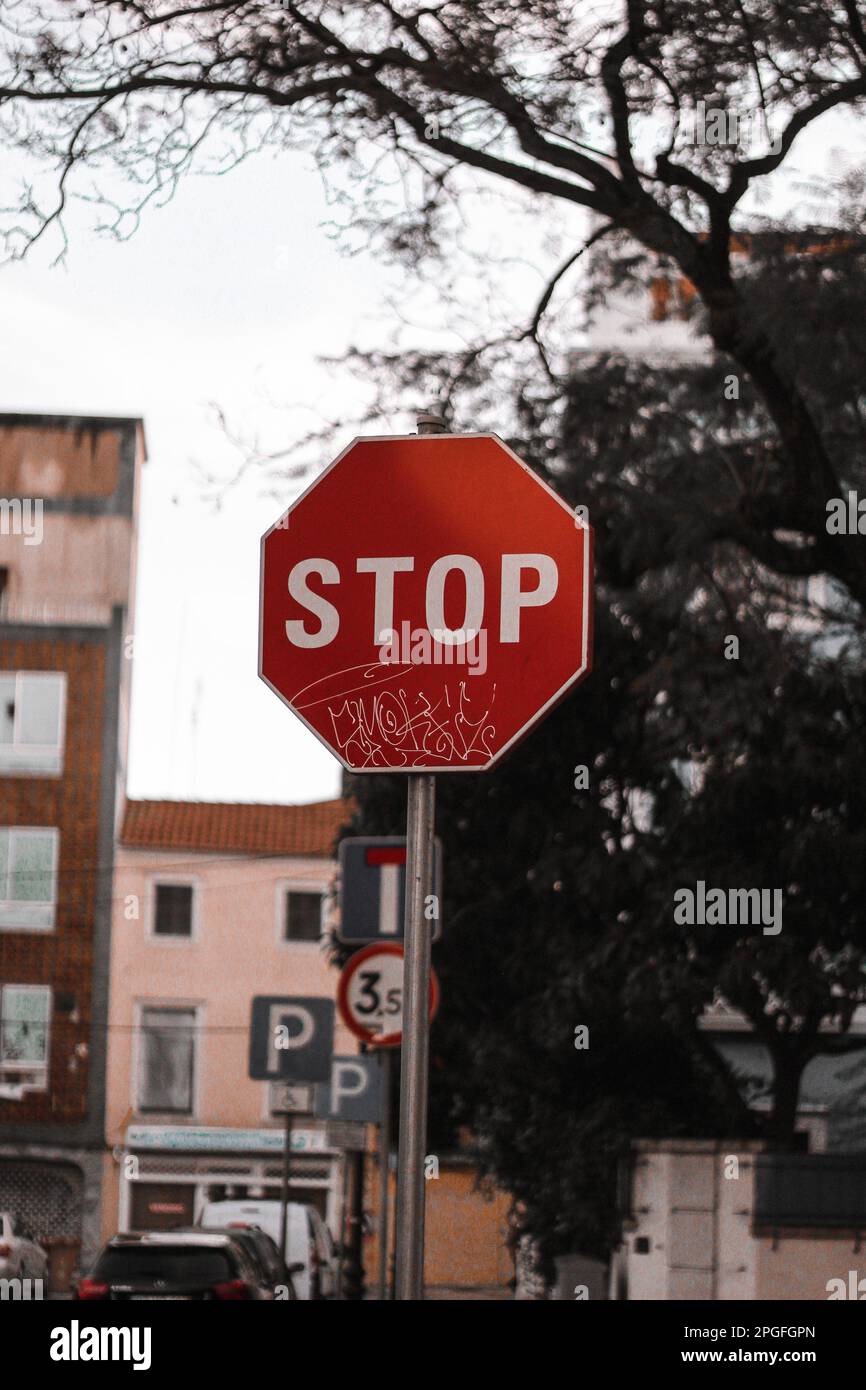 A red stop sign positioned at the side of a paved street Stock Photo ...