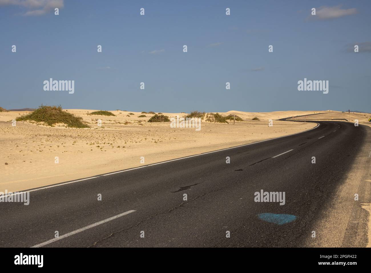 Good quality of the road through the desert. Sand of the dunes on both ...