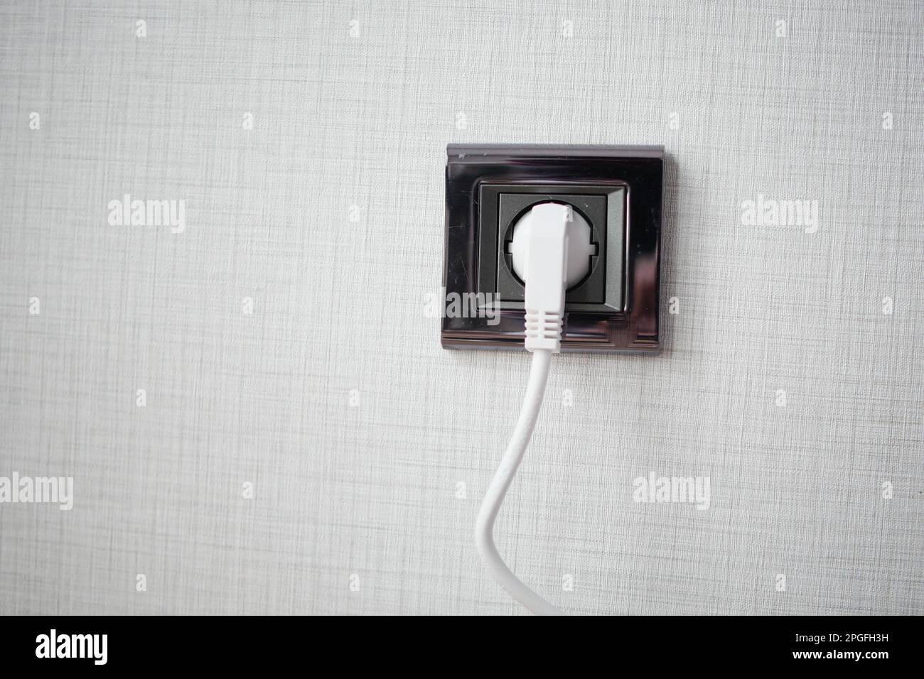 white color power cord cable plugged into wall Stock Photo - Alamy