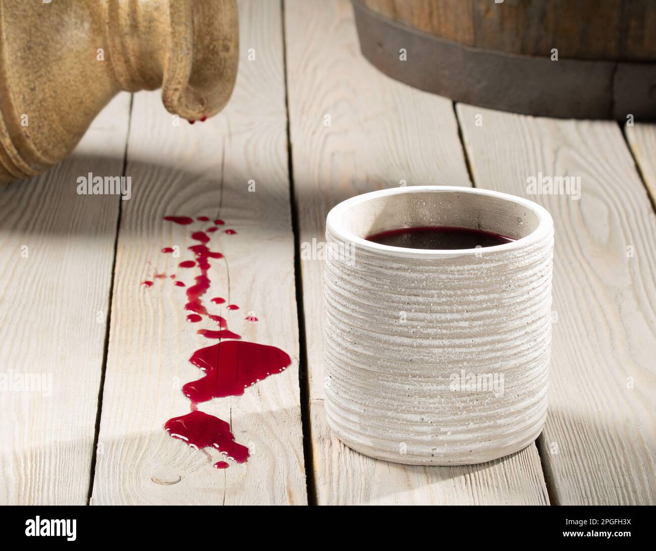 Clay jug for wine, wine barrel and clay glass of red wine on a wooden ...