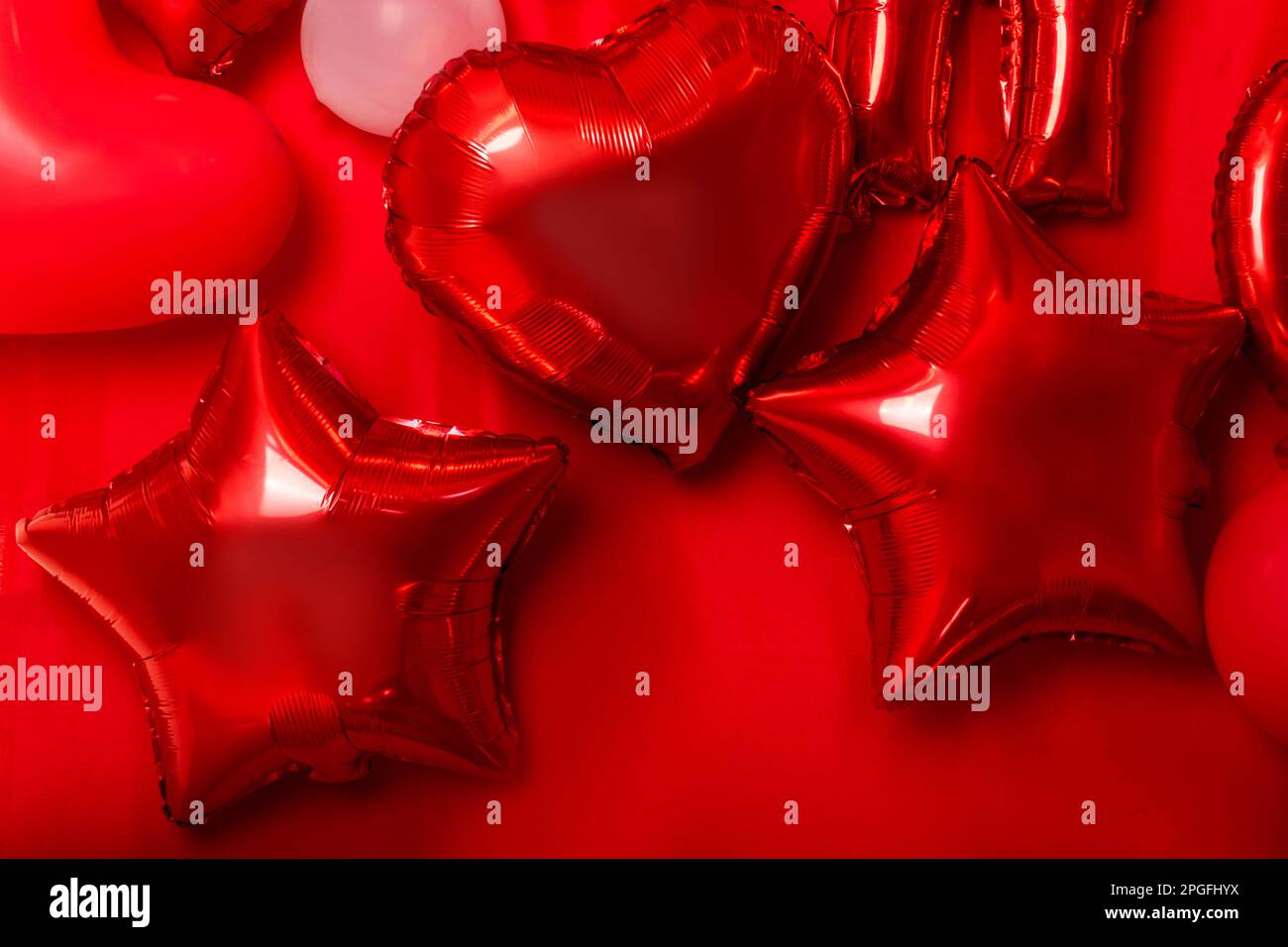 A large cluster of glimmering heart-shaped balloons in the center of a ...