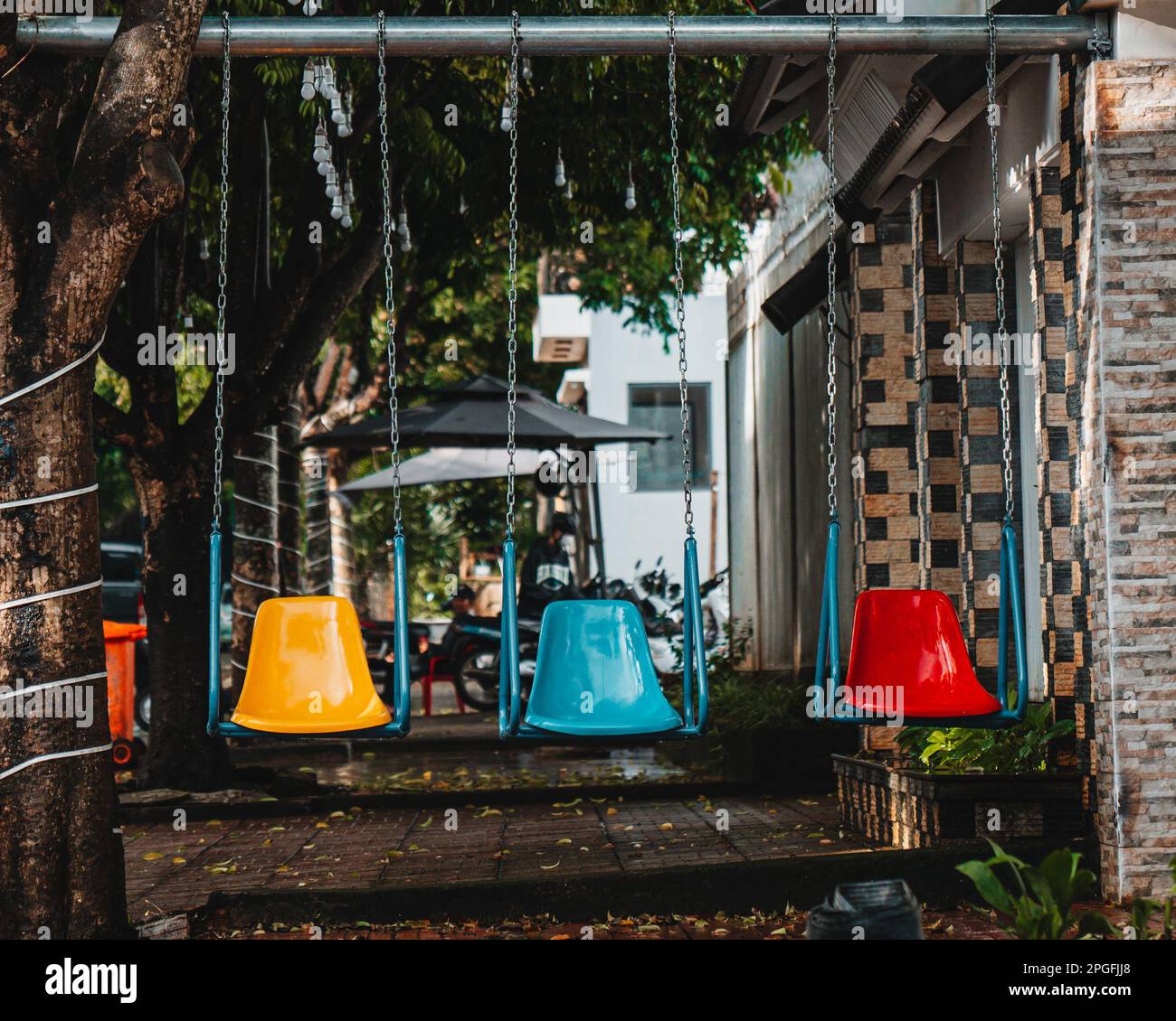 A cheerful outdoor scene of a park, featuring three colorful swings ...
