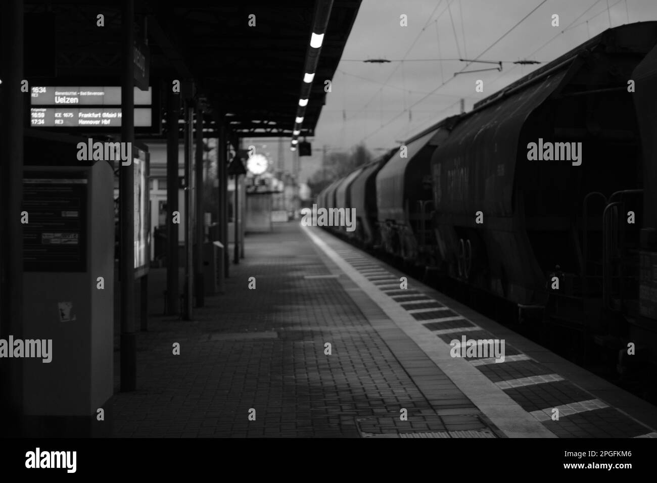 An urban train station scene featuring a stationary train, standing ...
