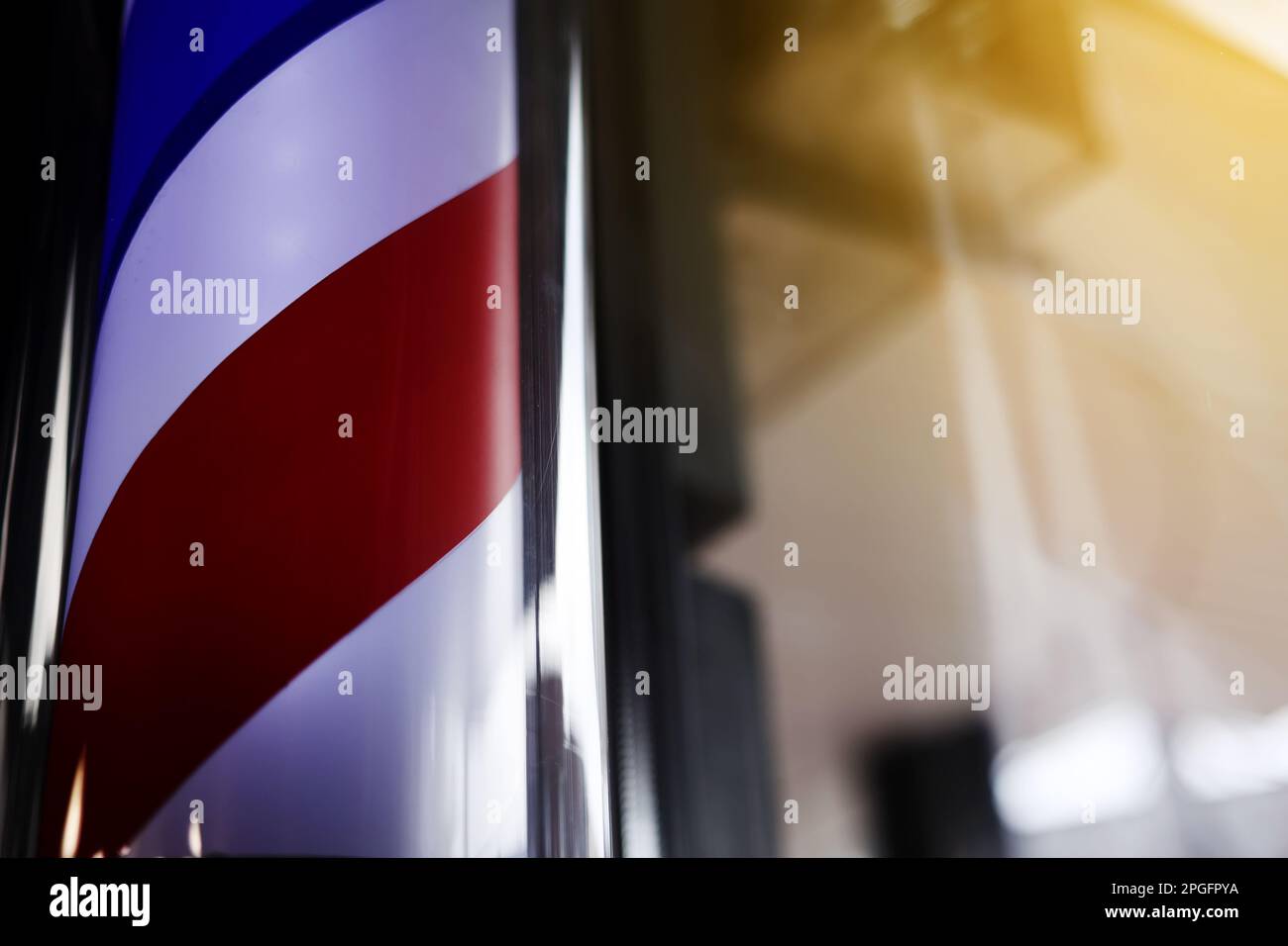 Barber pole spinning at night. International barbershop pole sign. A ...