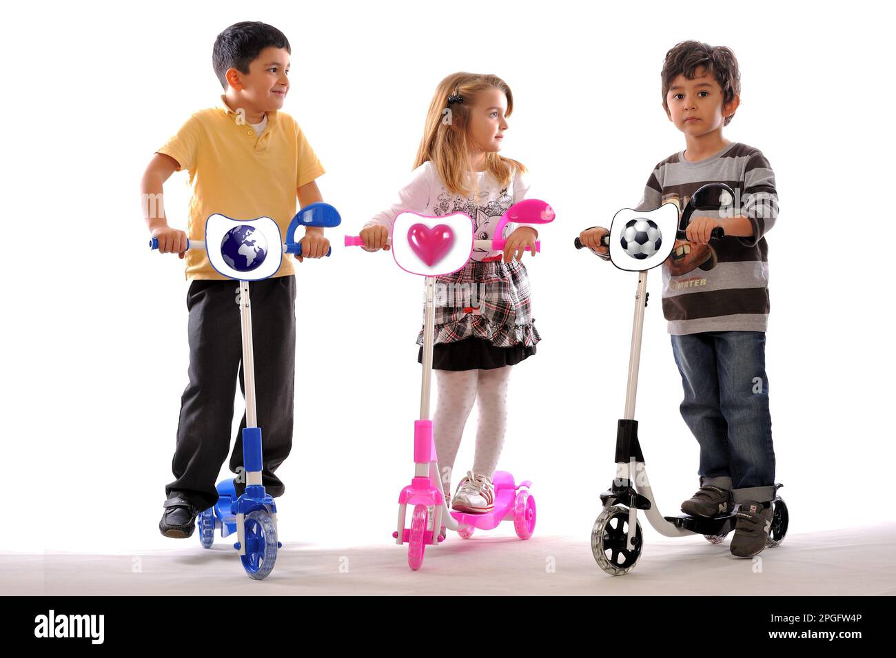 three cute little kids are very happy riding scooter on white ...