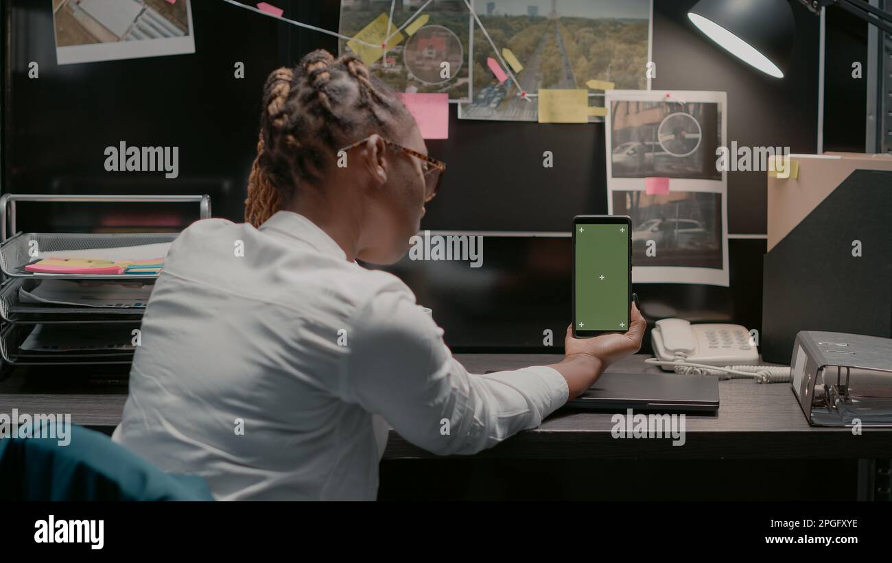 Law officer holding mobile pohne with greenscreen, young detective ...