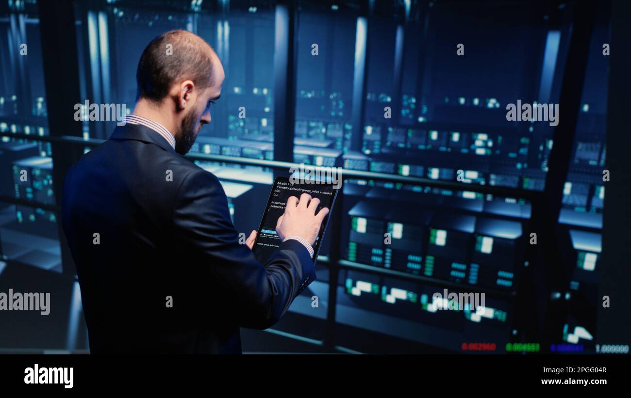 Datacenter engineer using tablet in modern server room, planning cluster computer service or ...