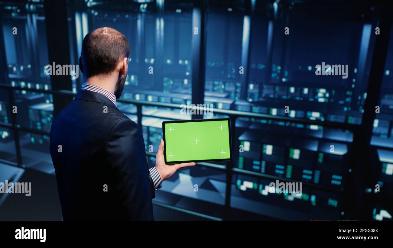 Support specialist using tablet with greenscreen display in modern data center, checking blank ...