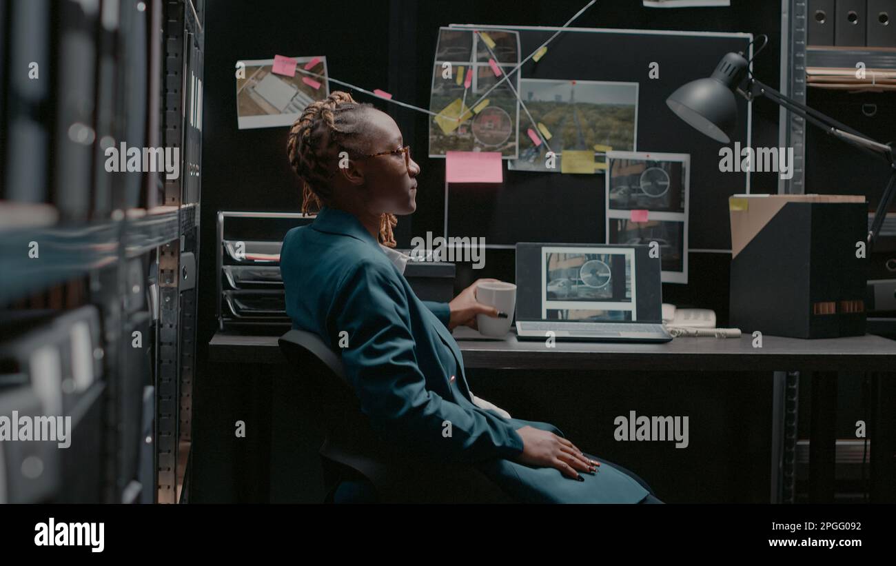 African american woman analyzing case records on detective board in ...
