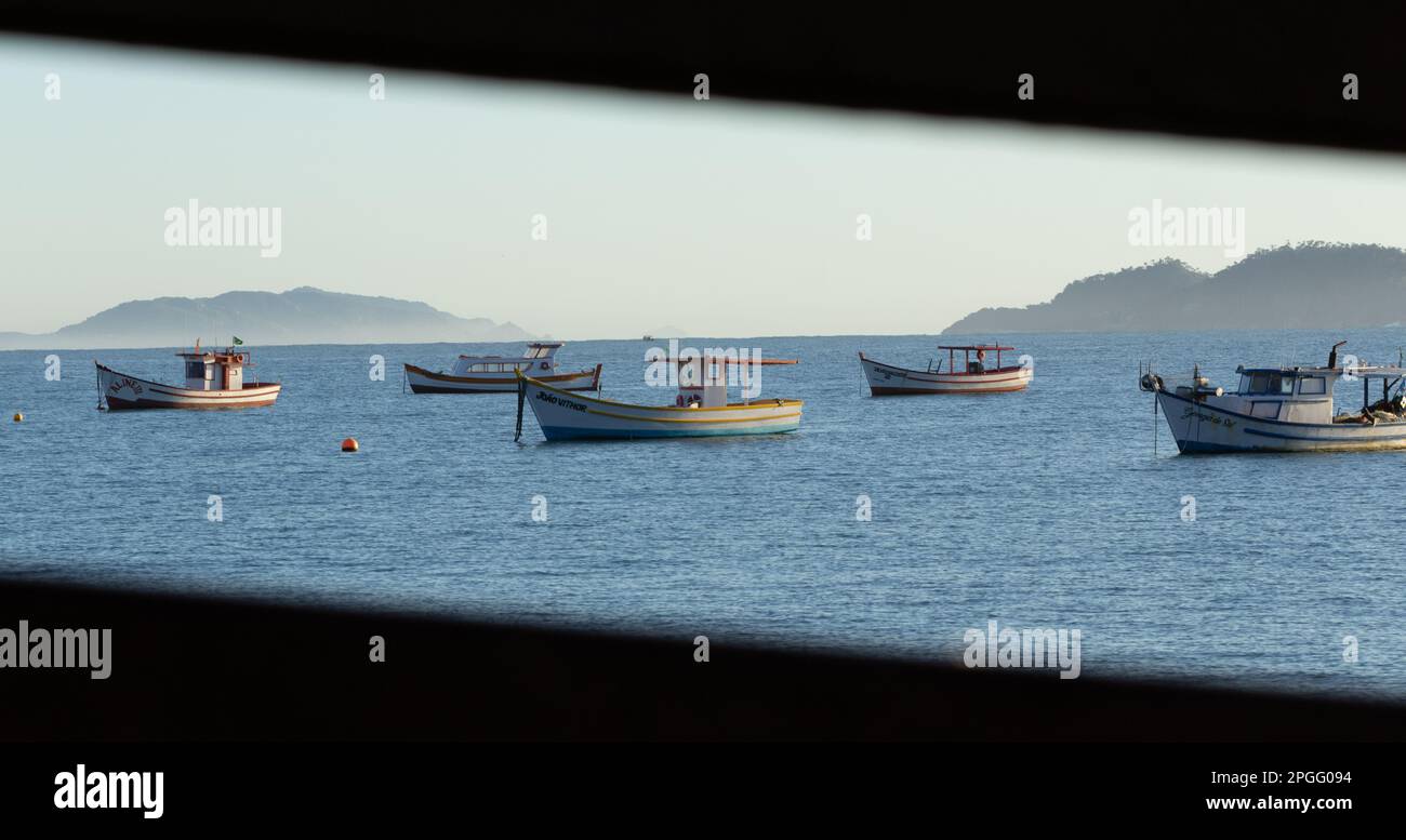 A cluster of small boats all bobbing in unison in a tranquil body of ...