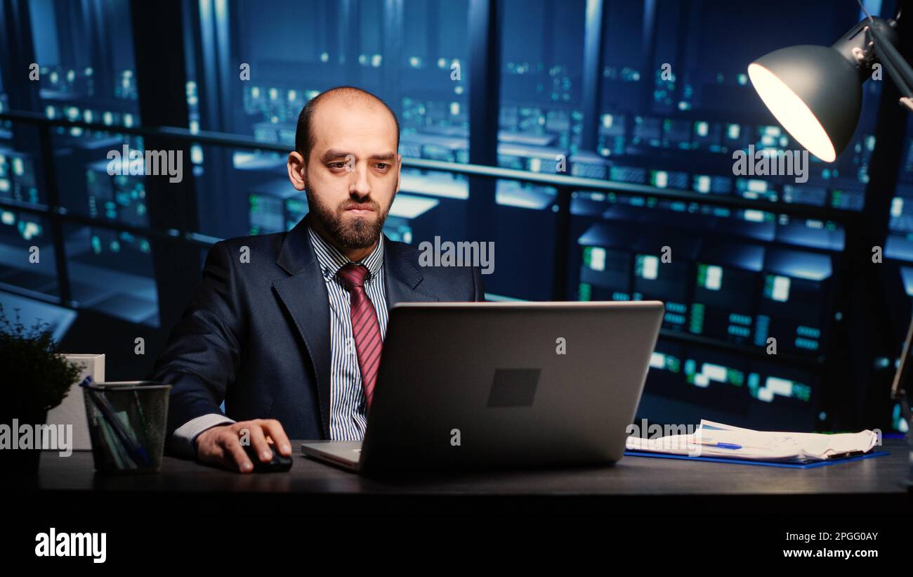 Server technician specialist working on laptop running networking ...