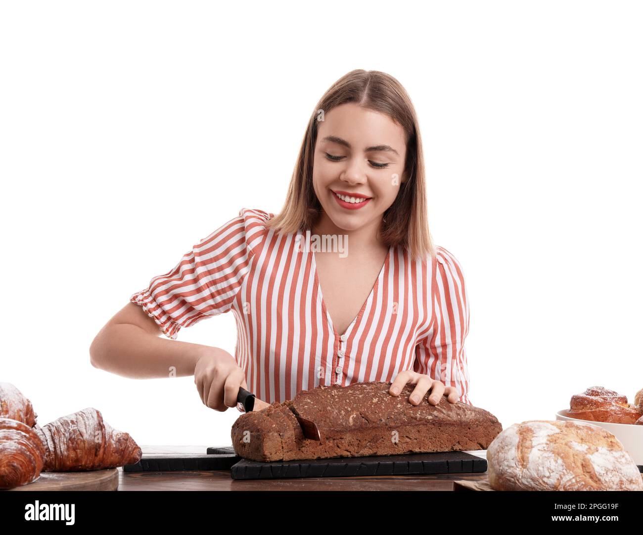 Female baker cutting fresh bread at table on white background Stock ...