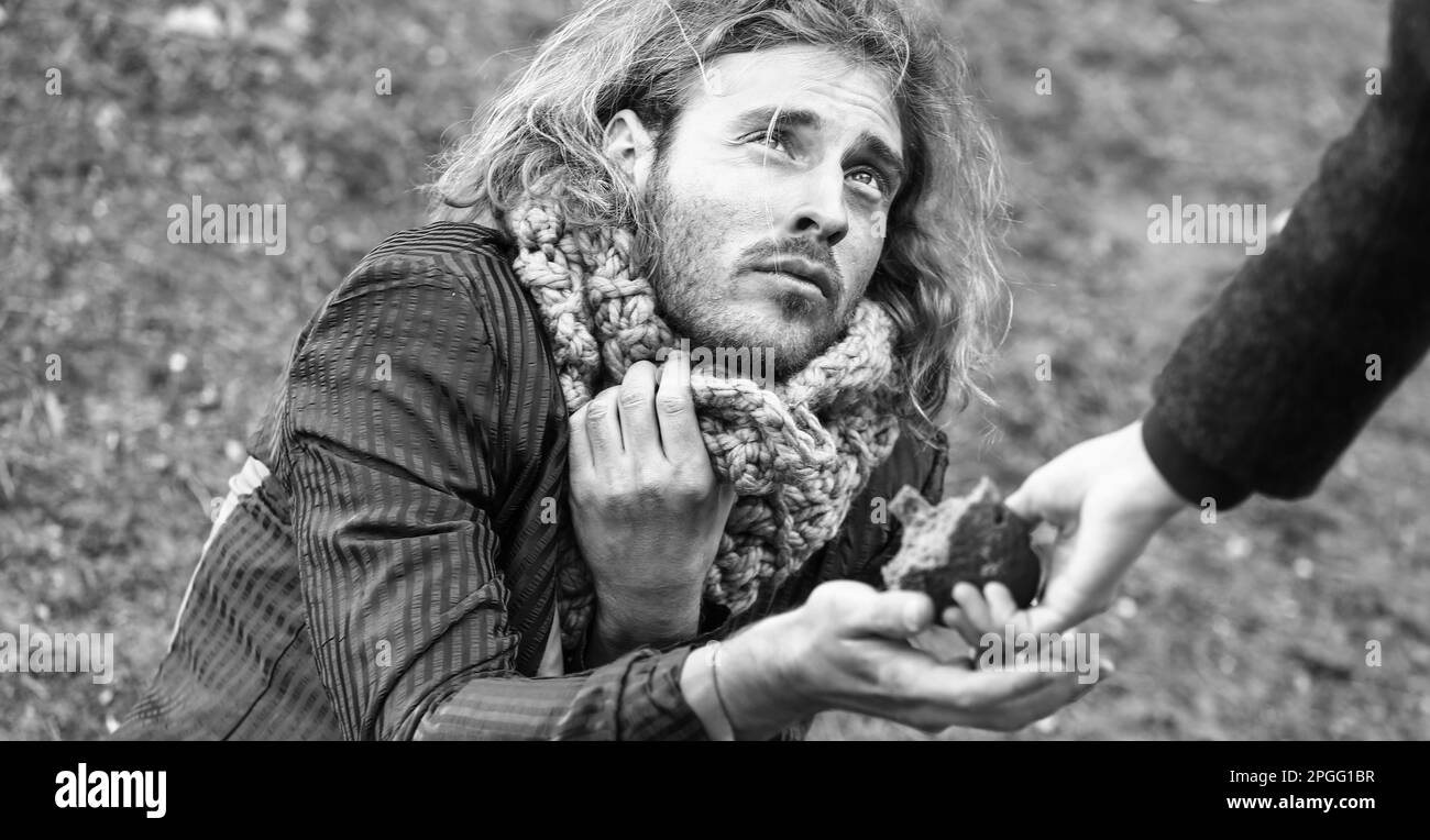 Woman giving bread to poor homeless man Stock Photo - Alamy