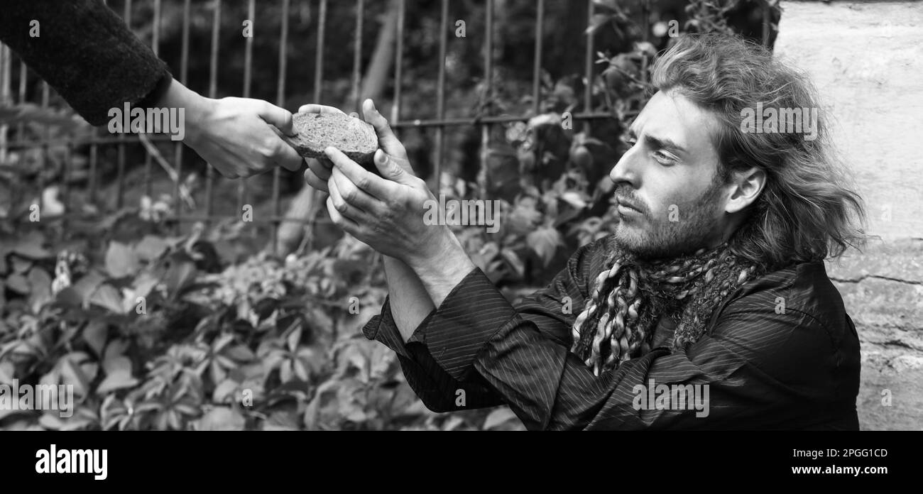 Woman giving bread to poor homeless man outdoors Stock Photo - Alamy