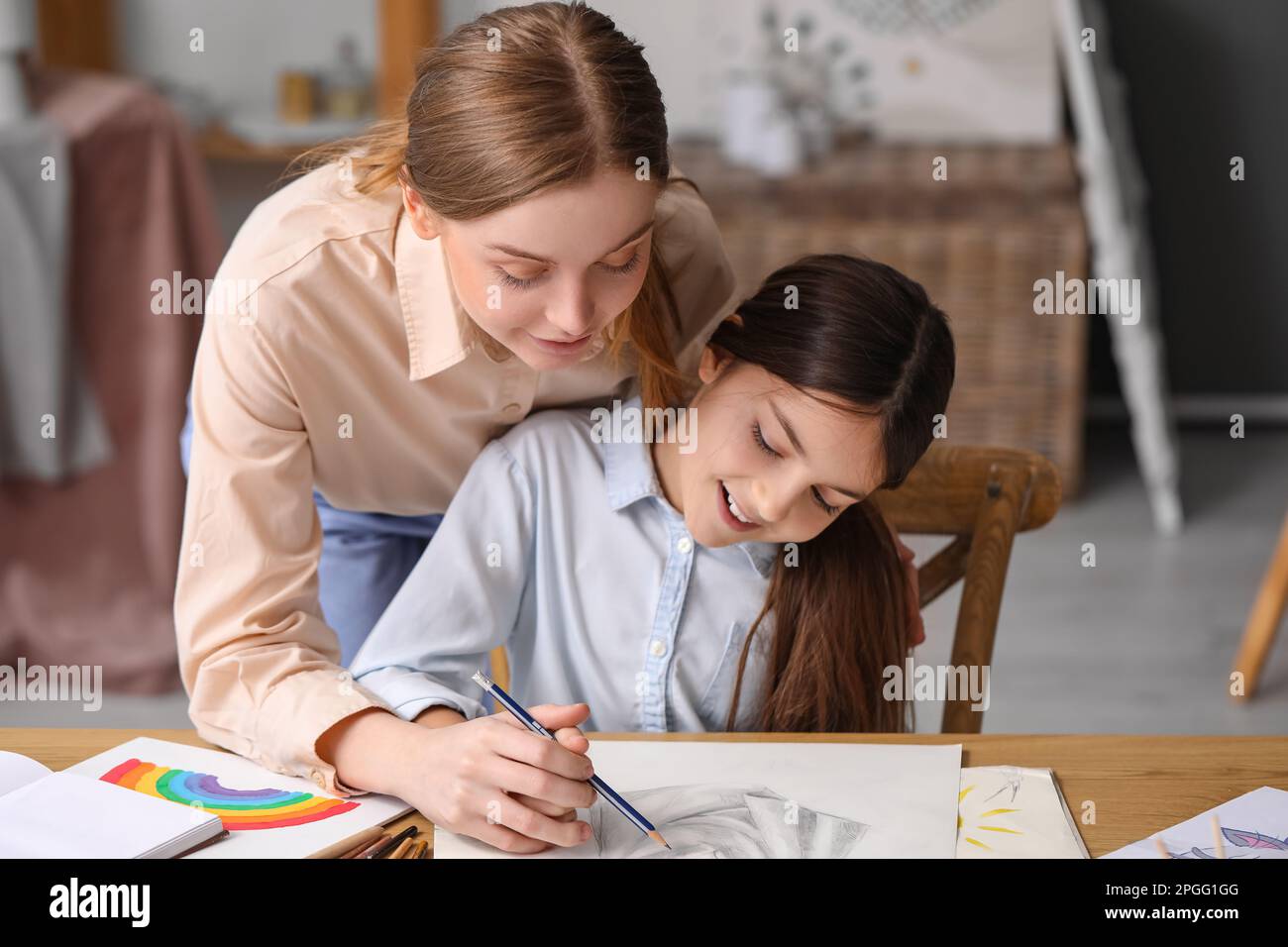 Drawing teacher with pencil giving private art lesson to little girl in ...