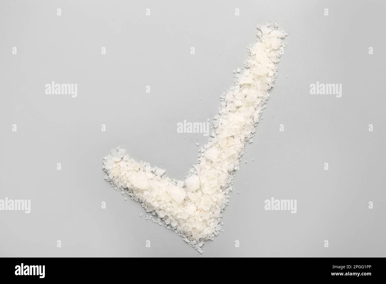 Check mark made of sea salt on grey background Stock Photo - Alamy
