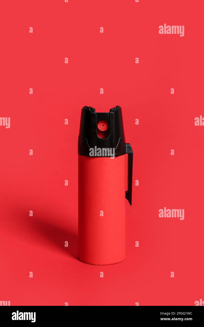 Pepper spray on red background Stock Photo - Alamy