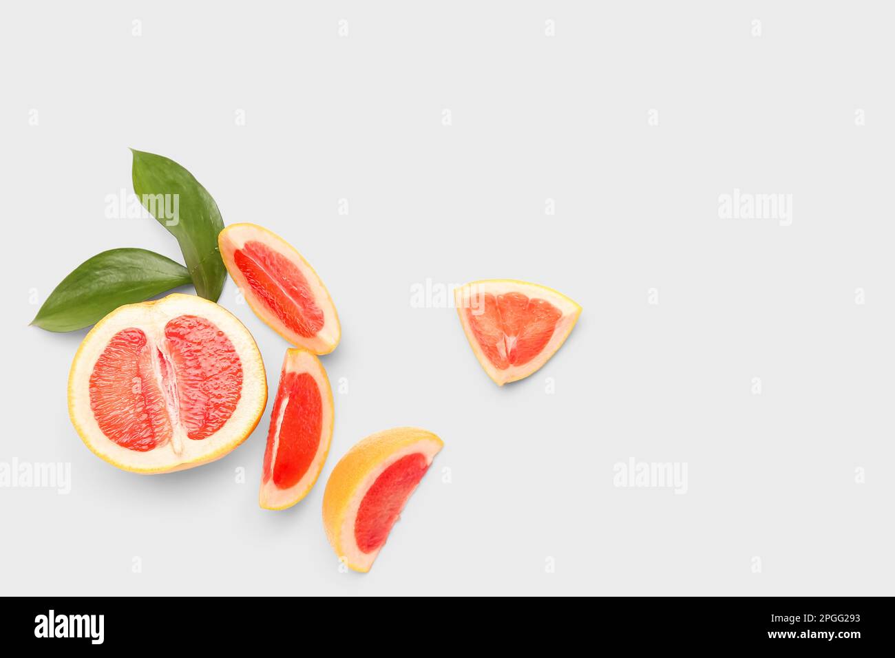 Pieces of ripe grapefruit and plant leaves on white background Stock ...