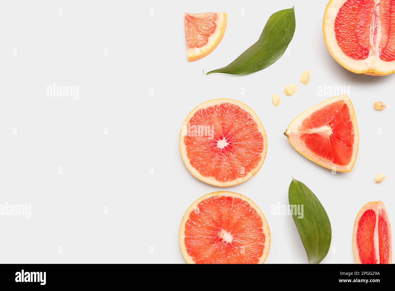 Composition with pieces of ripe grapefruit, seeds and plant leaves on ...