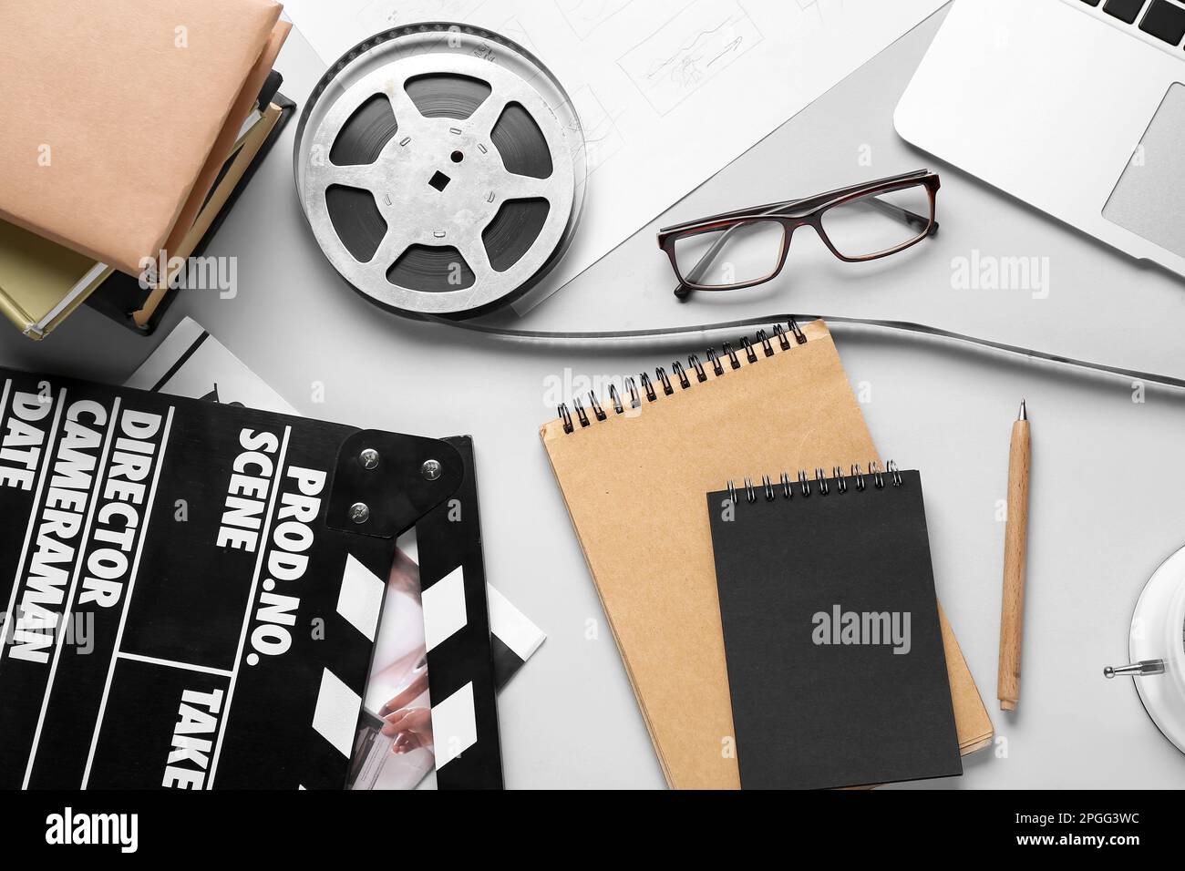 Notebooks with film reel and movie clapper on grey background Stock ...