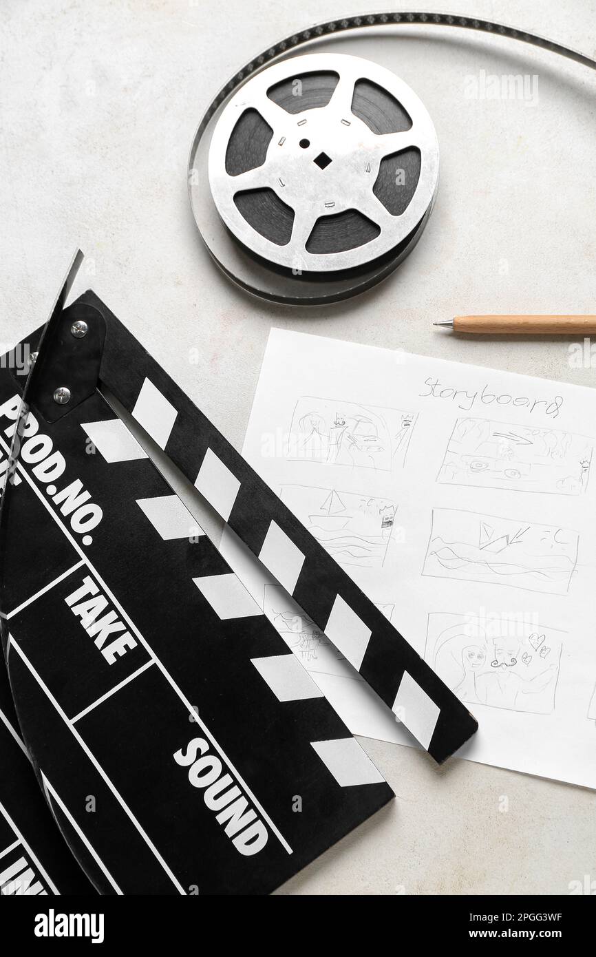 Movie clapper with storyboard and film reel on light background Stock ...