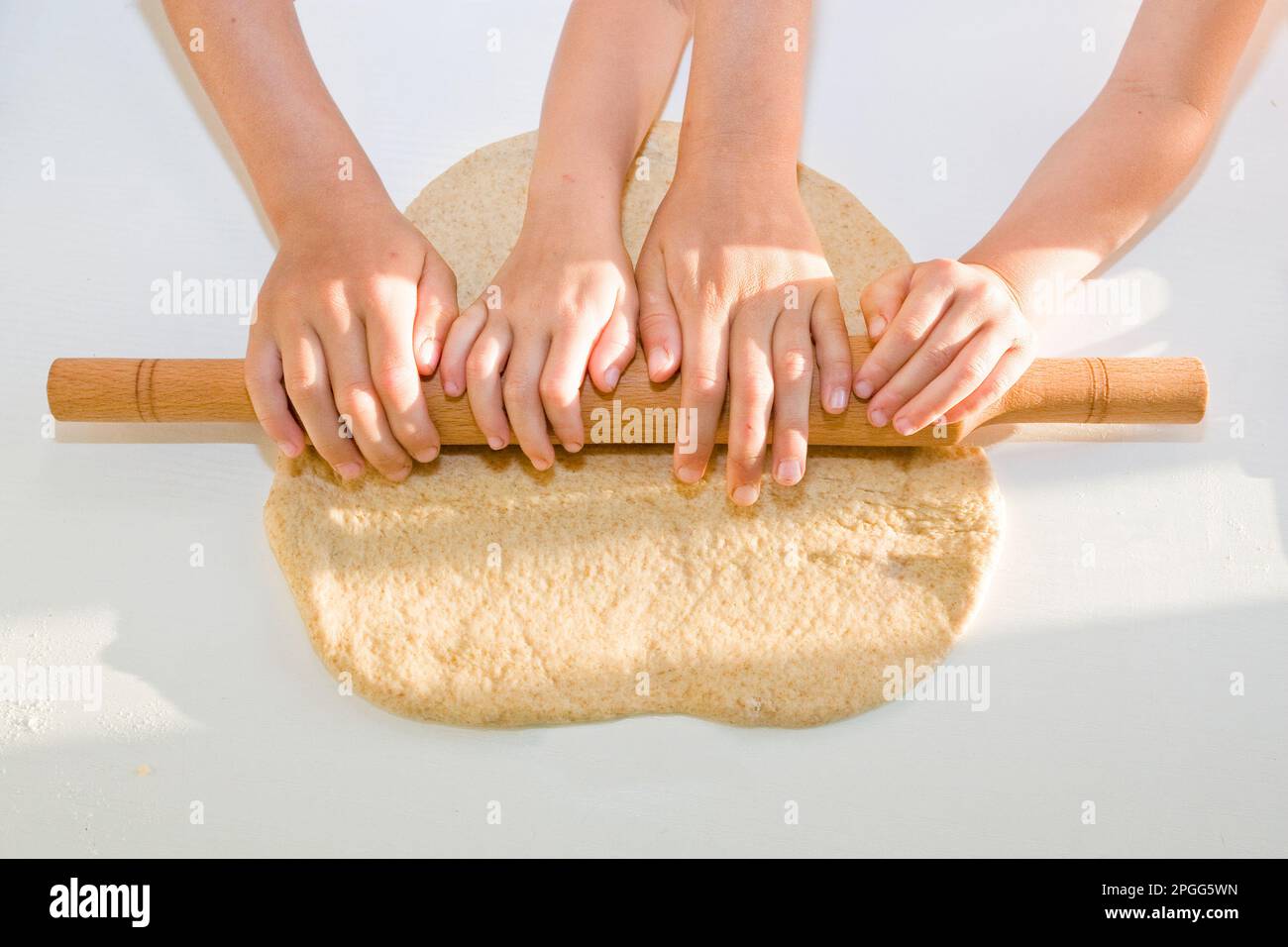 Girls roll out dough in the sun Stock Photo - Alamy