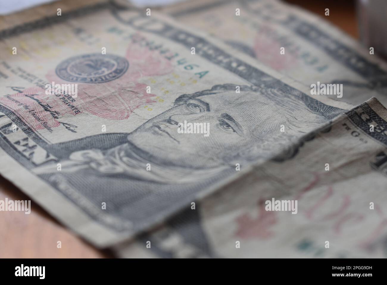 American 10 (ten) dollar bills lying on a table. Portrait of Alexander ...