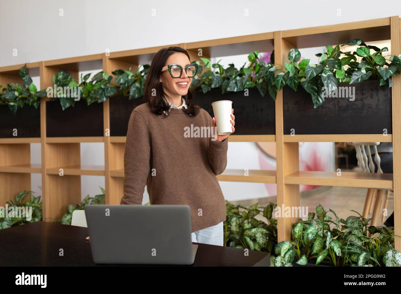 Happy European Female Entrepreneur Standing Near Desk With Laptop ...