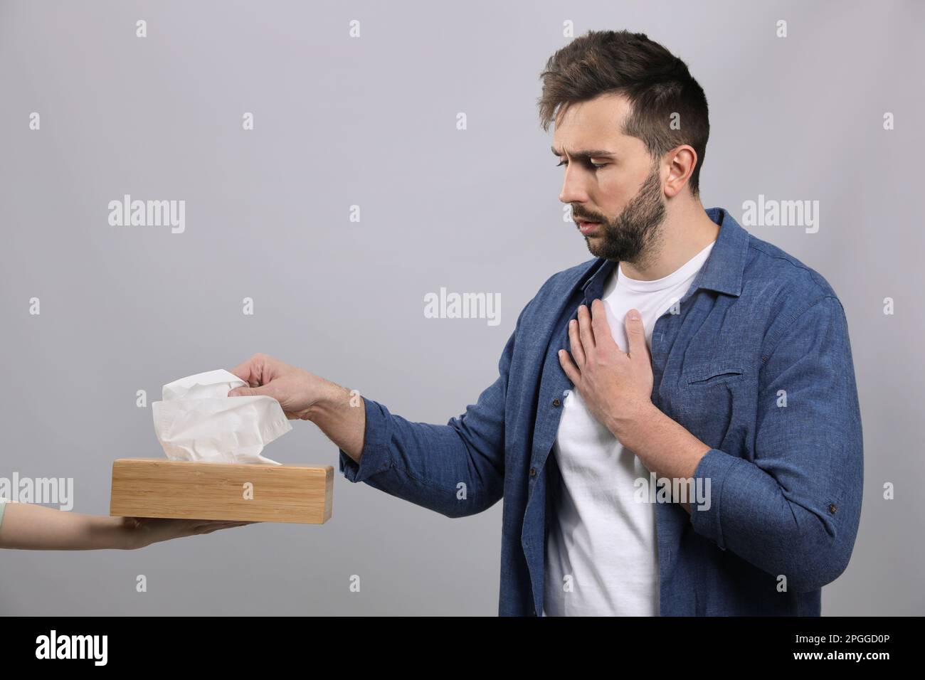 Sick man taking tissue on grey background. Cold symptoms Stock Photo ...