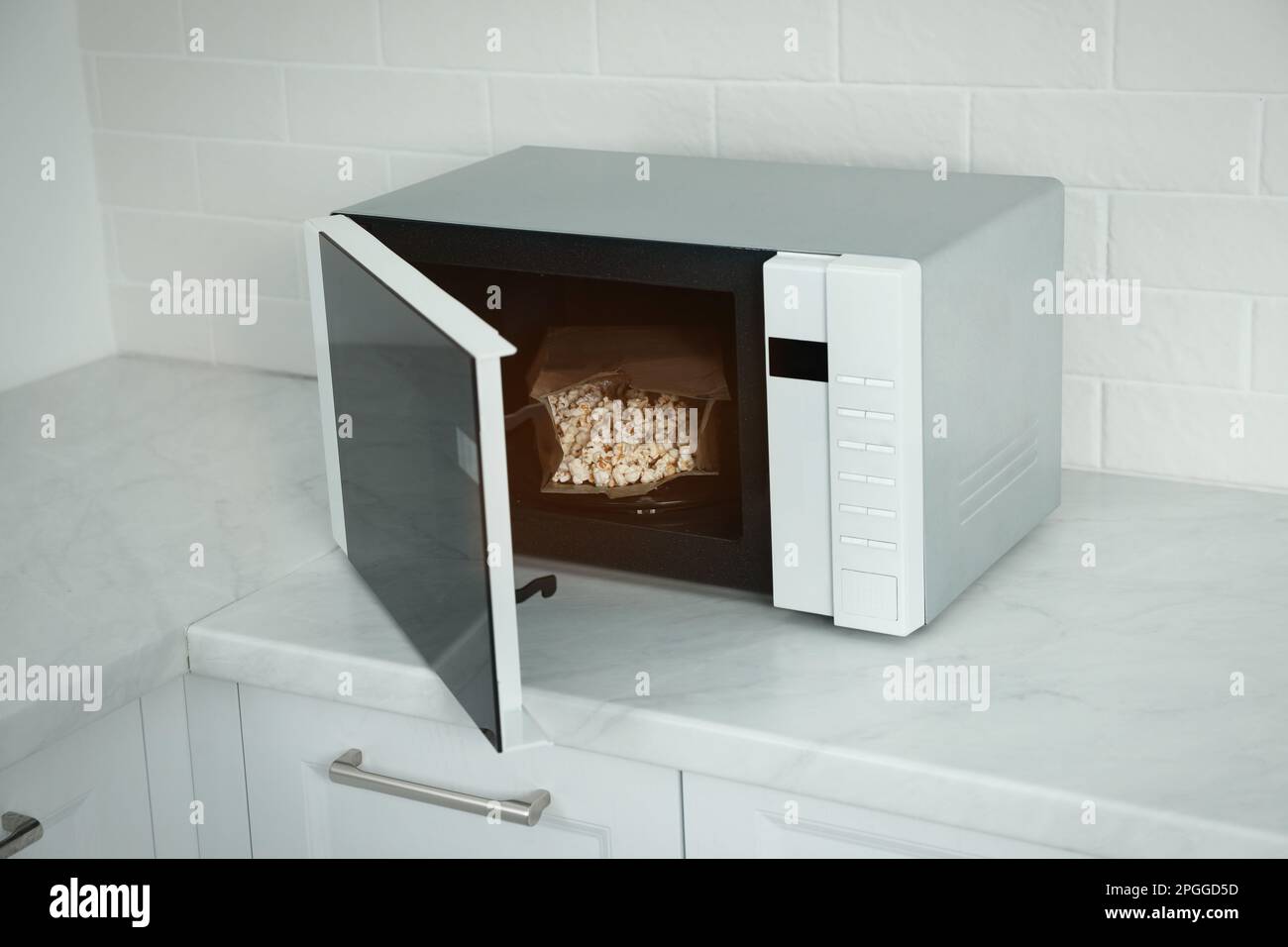 Open microwave oven with fresh popcorn on countertop in kitchen Stock ...