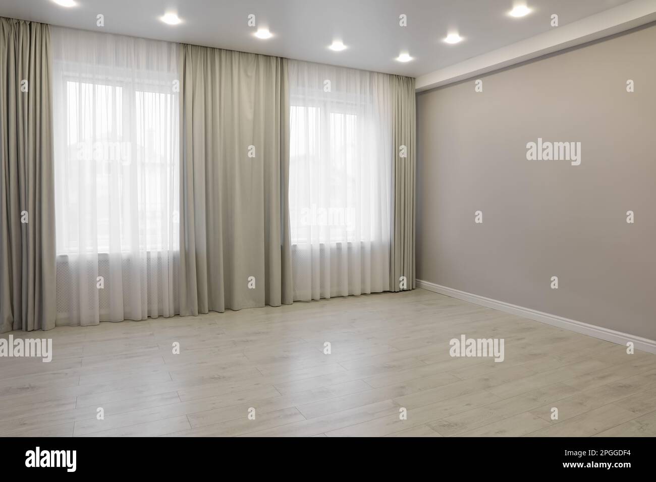 Empty room with beige wall, large window and wooden floor Stock Photo ...