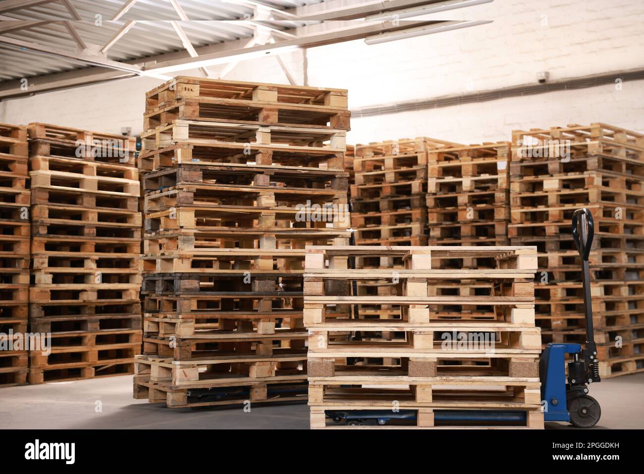 Modern manual forklift and wooden pallets in warehouse Stock Photo - Alamy