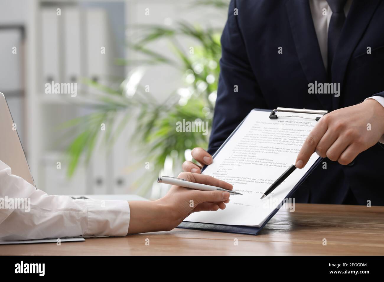 Woman signing employment agreement with HR manager in office, closeup ...