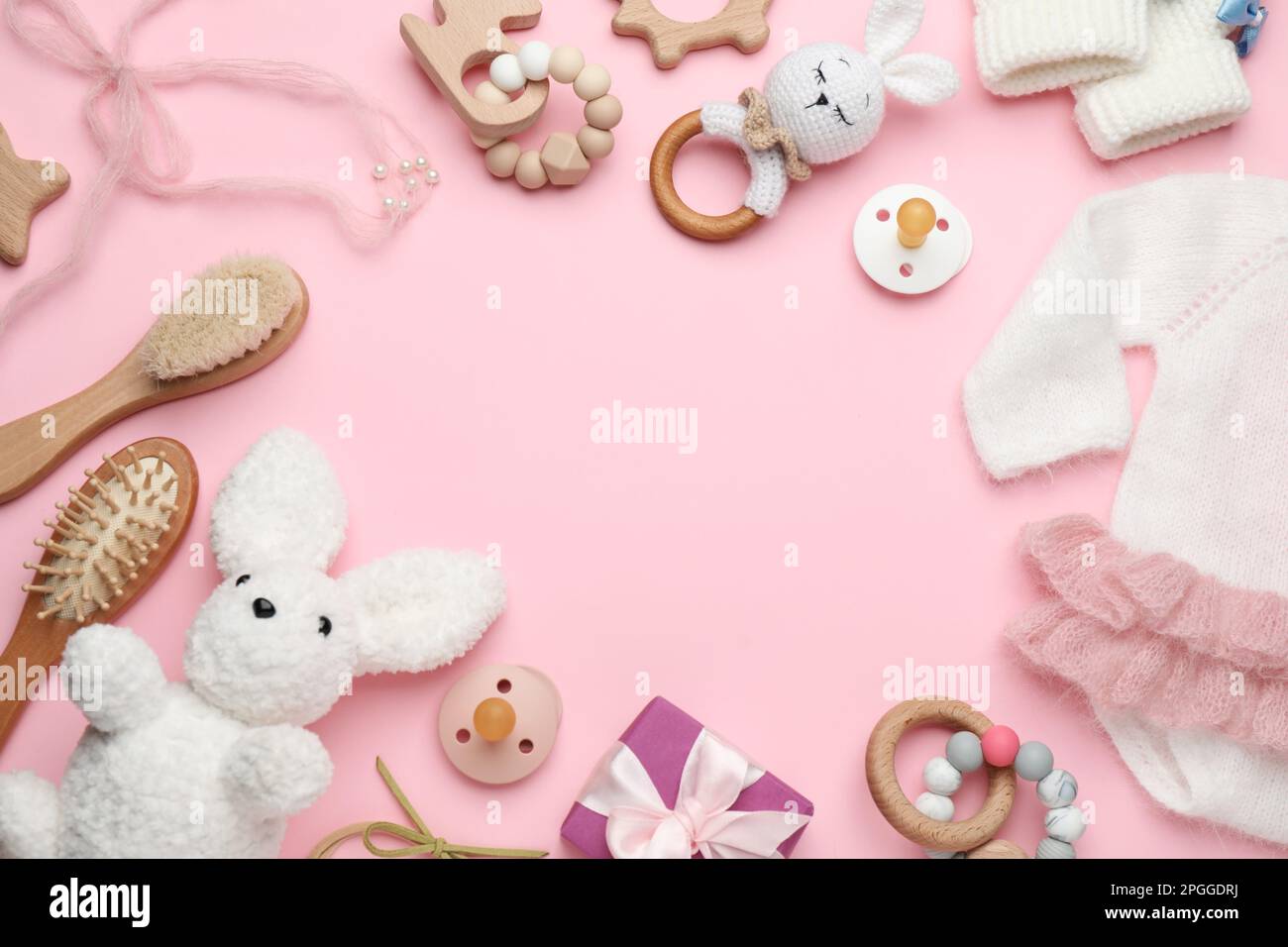 Frame of baby clothes and accessories on light pink background, flat ...