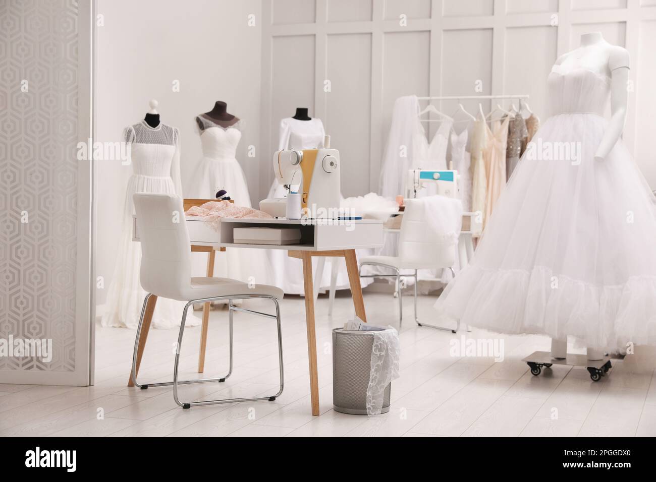 Dressmaking workshop interior with wedding dresses and equipment Stock ...