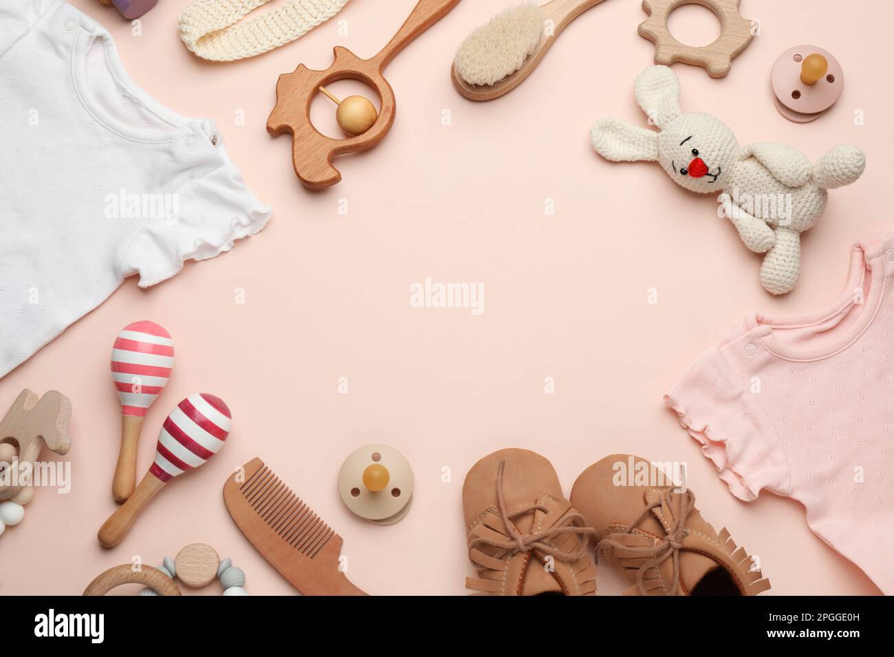 Frame of baby clothes and accessories on light pink background, flat ...