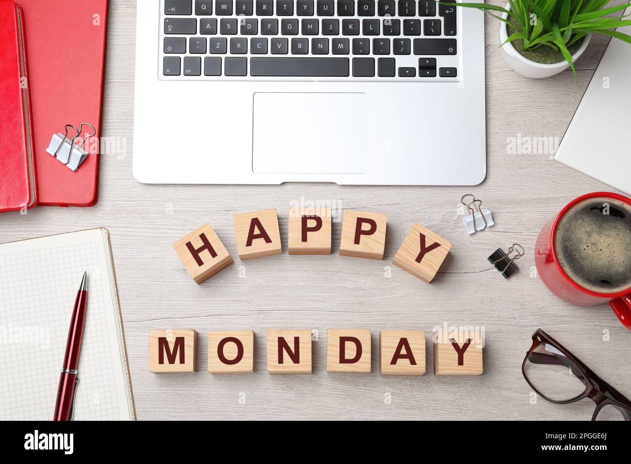 Cubes with message Happy Monday, office stationery and cup of coffee on ...