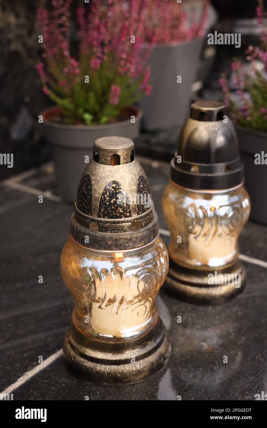 Grave lanterns on black tiled surface at cemetery Stock Photo - Alamy