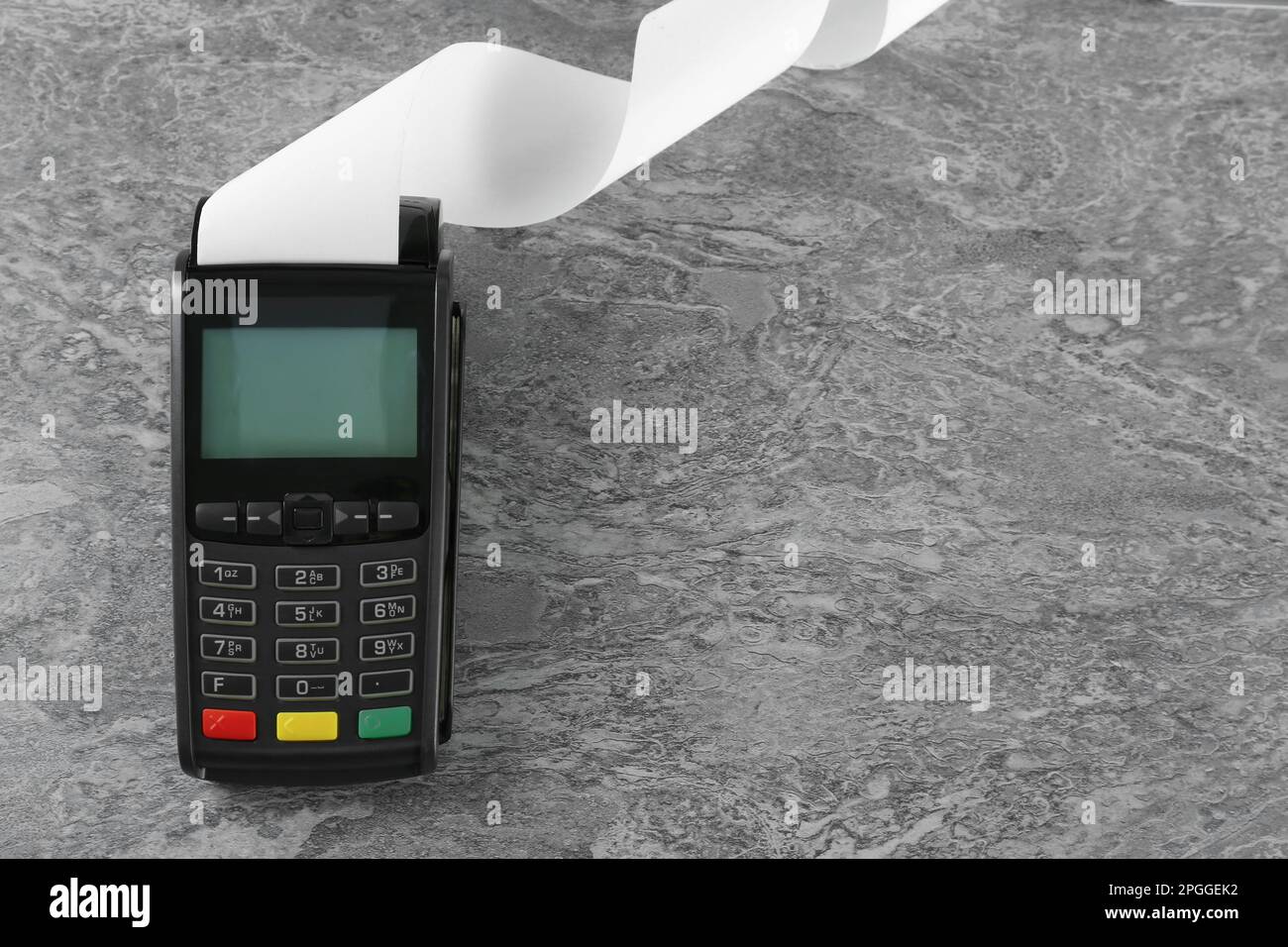New modern payment terminal with blank paper bill on grey table, top ...