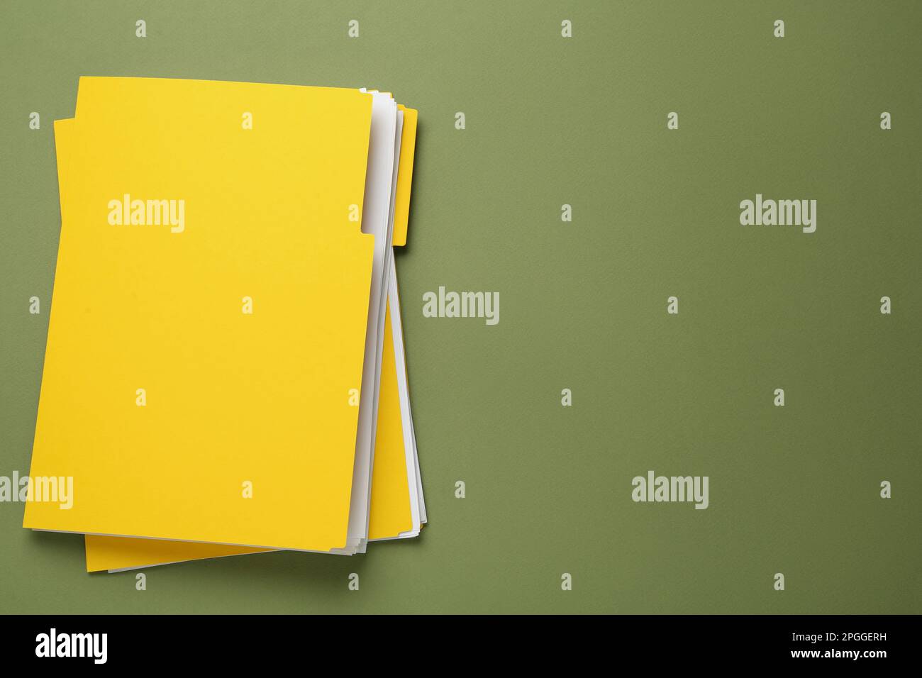 Yellow files with documents on olive background, top view. Space for ...
