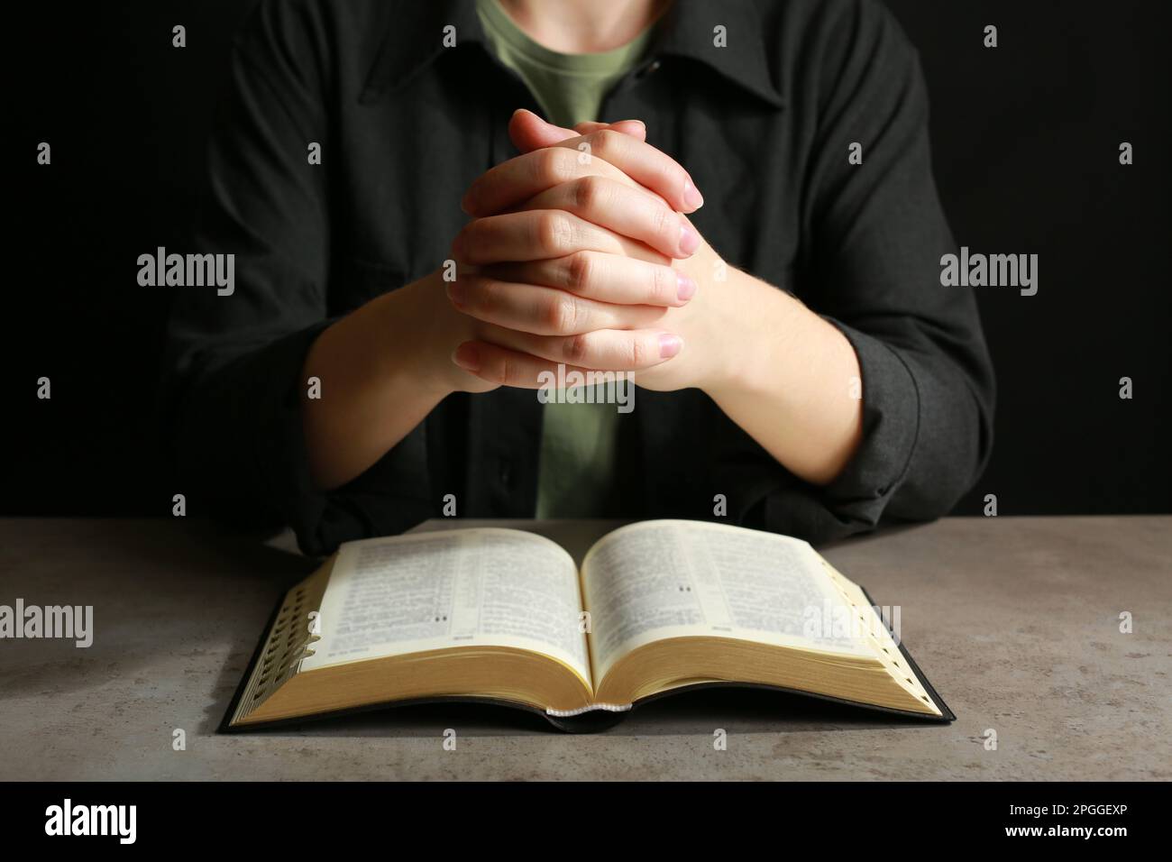 Woman praying over Bible at light grey table, closeup Stock Photo - Alamy