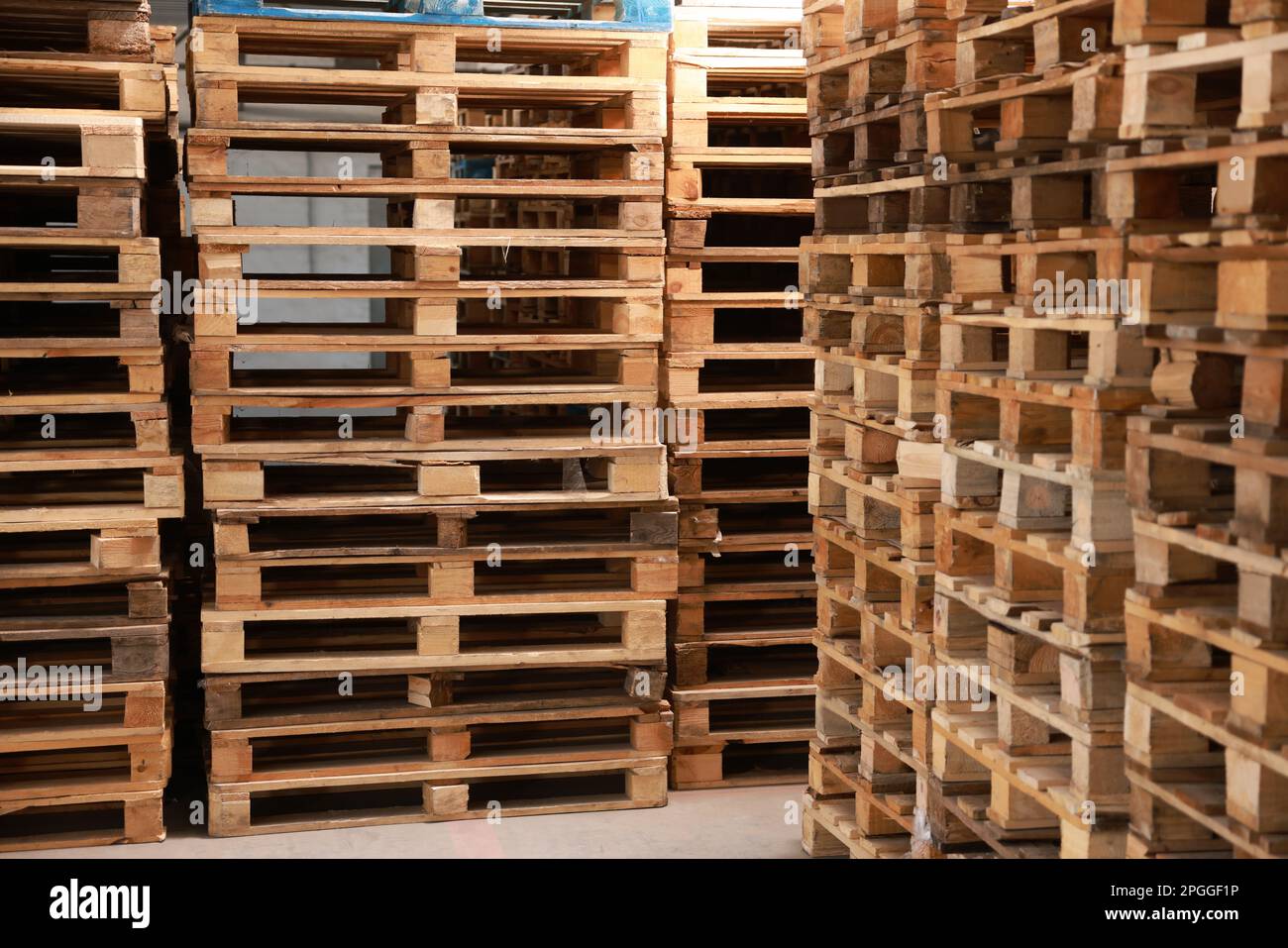 Many empty wooden pallets stacked in warehouse Stock Photo - Alamy