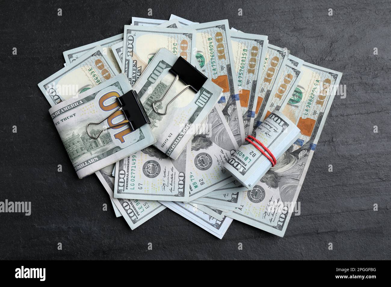 Many dollar banknotes on black table, top view. American national ...