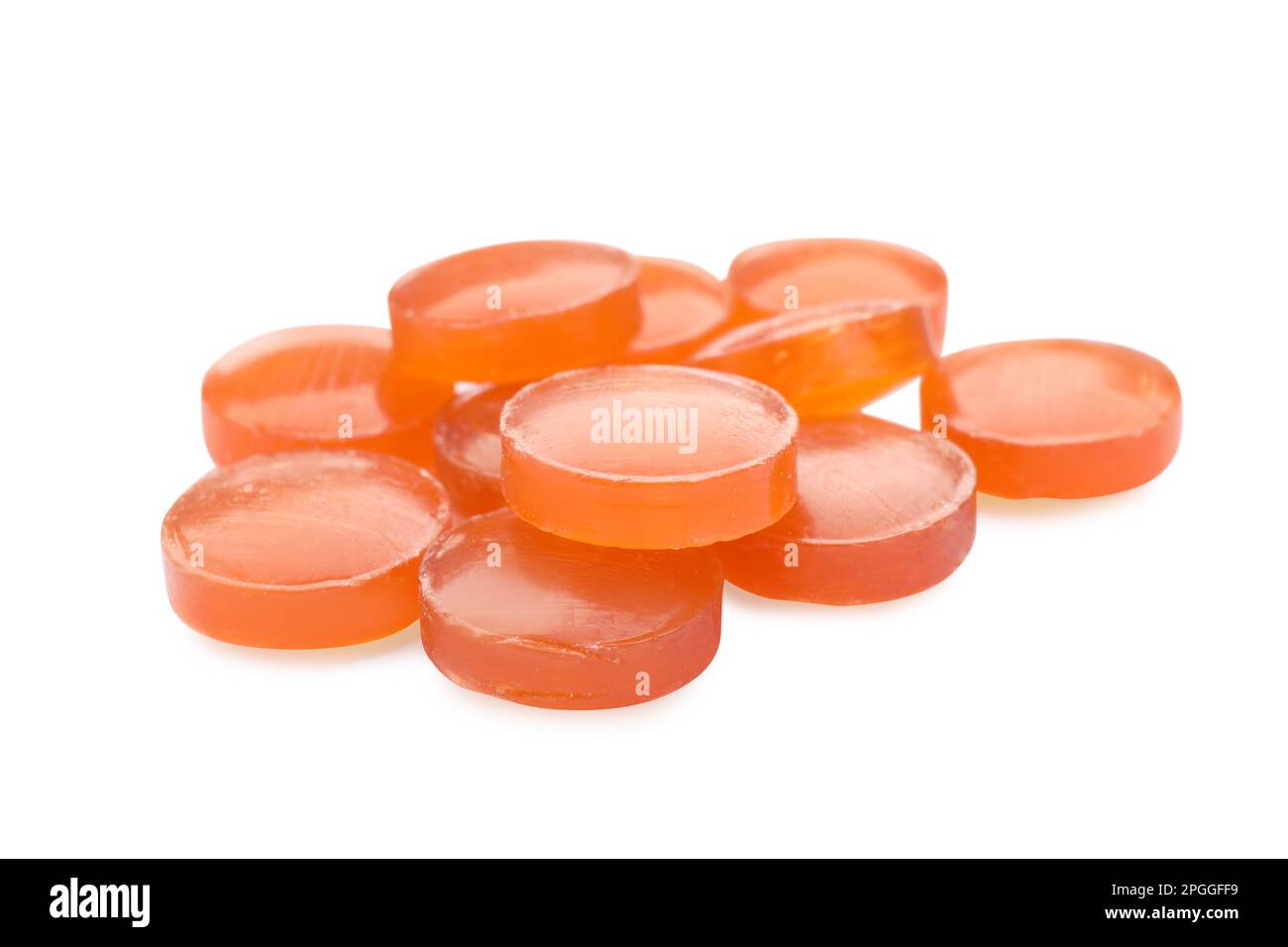 Many orange cough drops on white background Stock Photo - Alamy